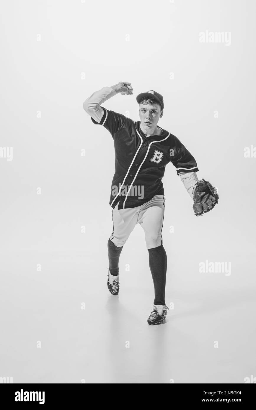 Portrait of young man, concentrated baseball player, pitcher in a glove ...