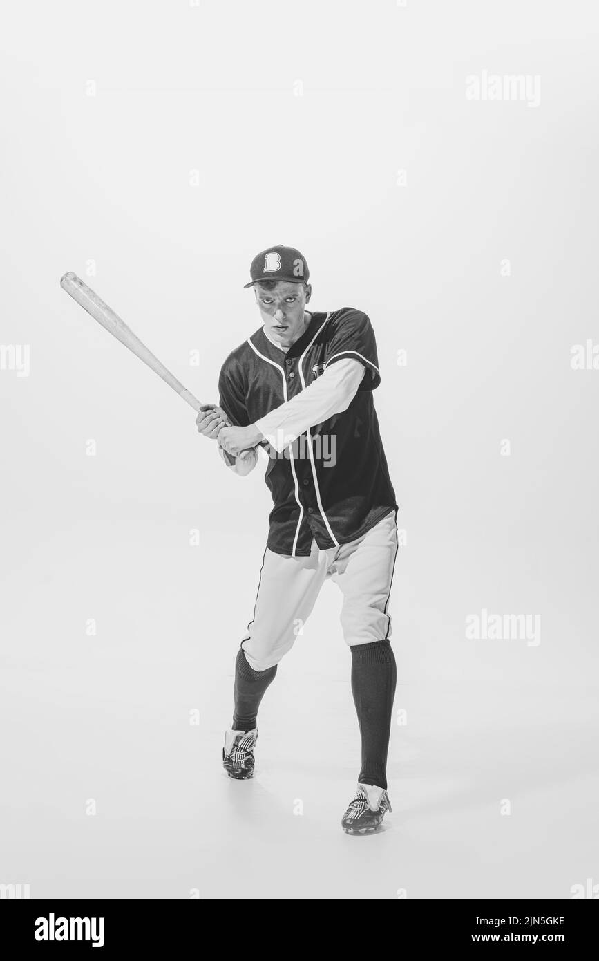 Portrait of young man, baseball player, batter ready to hit ball with ...