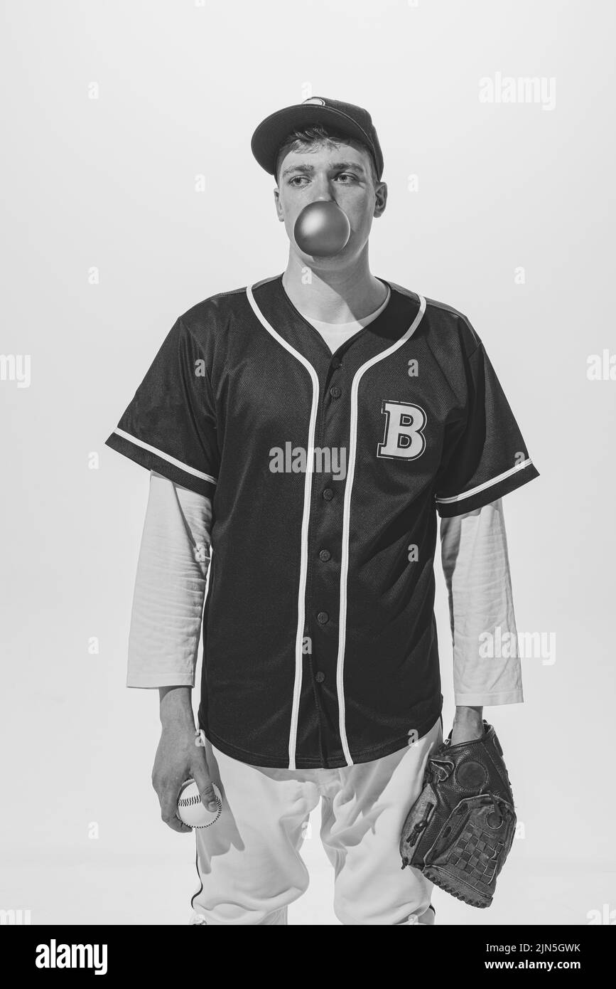 Portrait of young man, baseball player in uniform with bubblegum, in ...