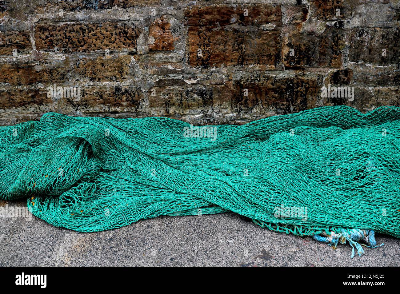 Fishing nets drying in the open air at an old harbour wall Stock Photo ...