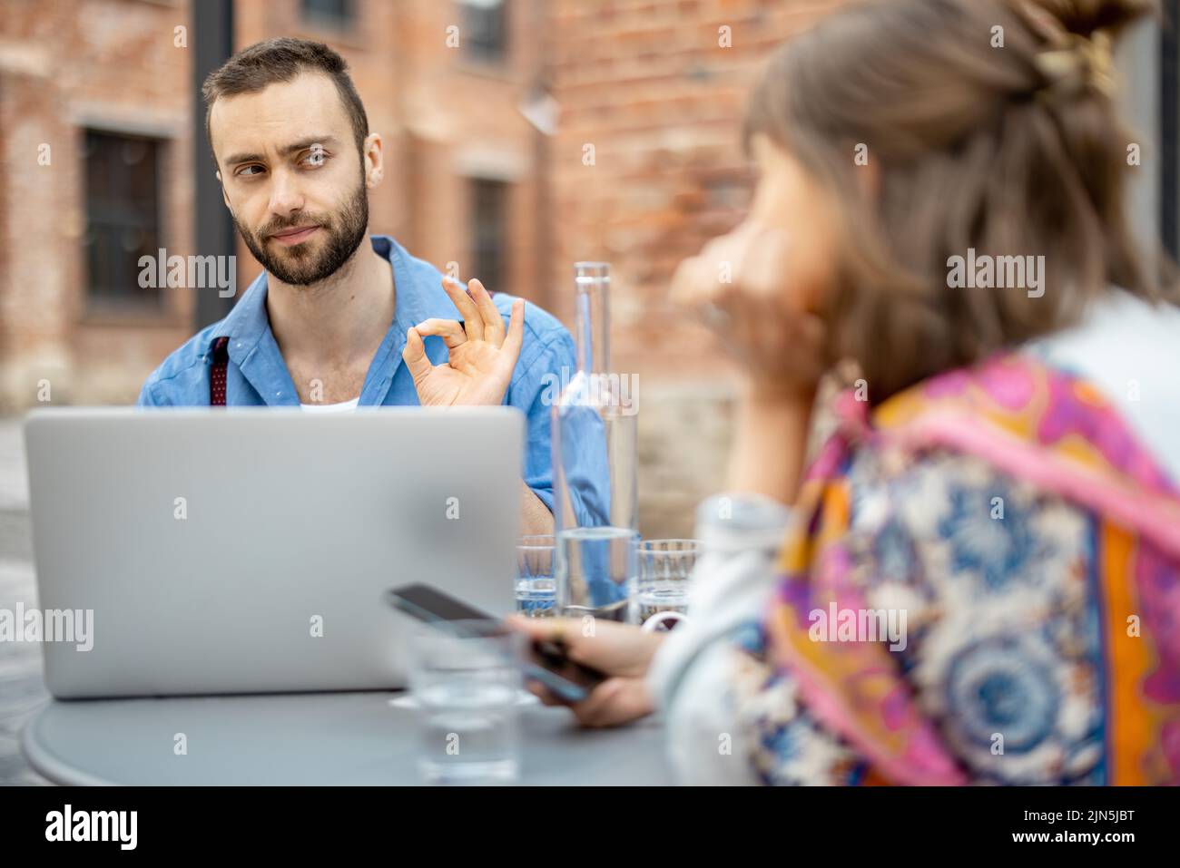 Stylish man talks with his female colleague at cafe Stock Photo - Alamy