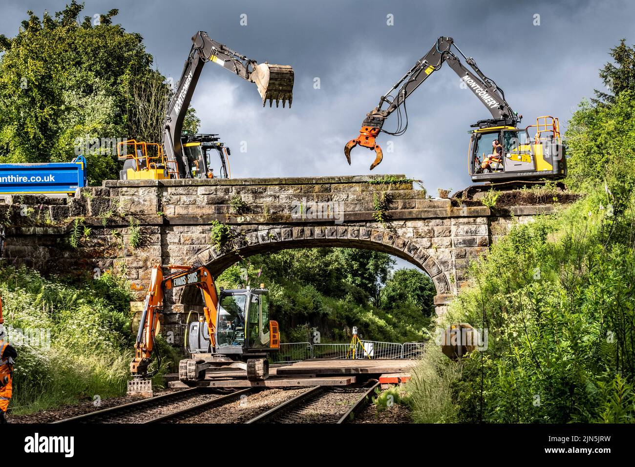 Railway workers building new railway and knocking down bridges Stock ...