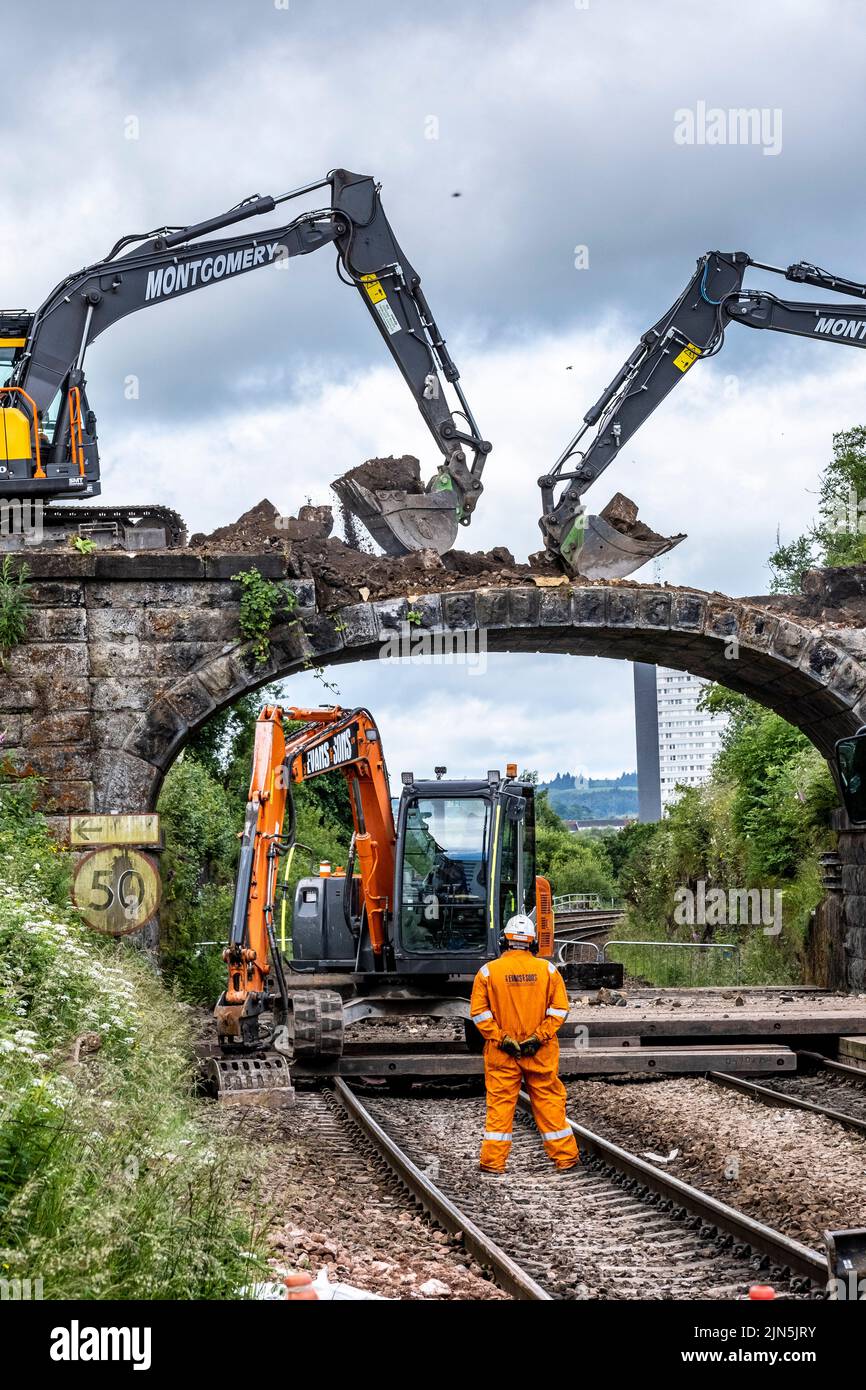 Railway workers building new railway and knocking down bridges Stock ...