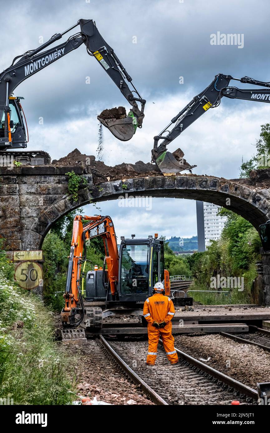 Railway workers building new railway and knocking down bridges Stock ...