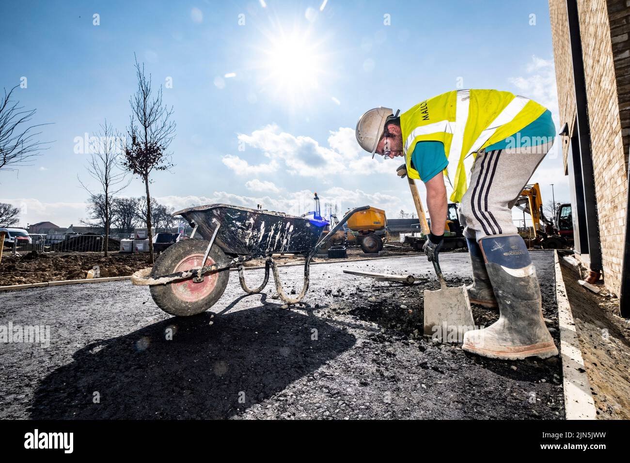 Construction workers in action on construction site Stock Photo - Alamy