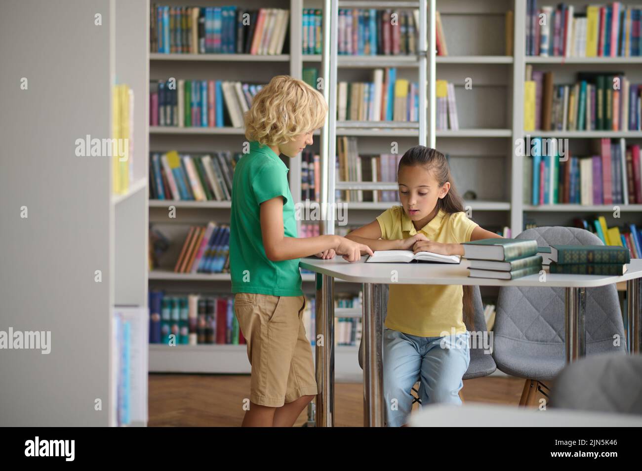 Two classmates studying together in the school library Stock Photo - Alamy