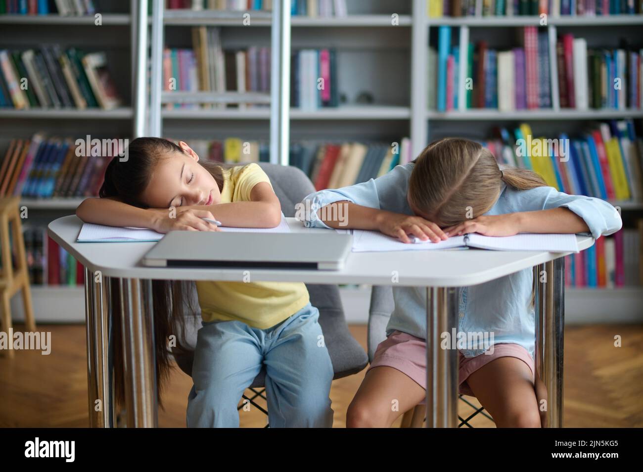 Two tired classmates dozing in the school library Stock Photo - Alamy