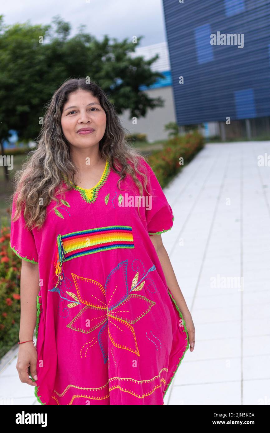 Portrait of a beautiful young indigenous girl wearing a colorful dress ...