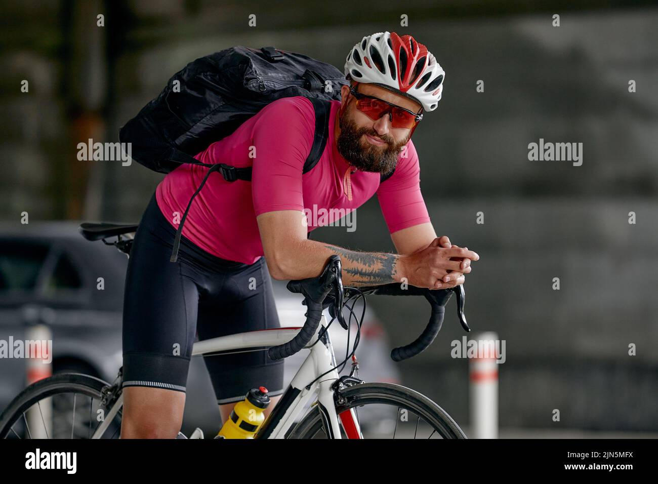 Portrait of a cyclist standing under a bridge with a bicycle, posing at ... Portrait of a cyclist standing under a bridge with a bicycle, posing at ...