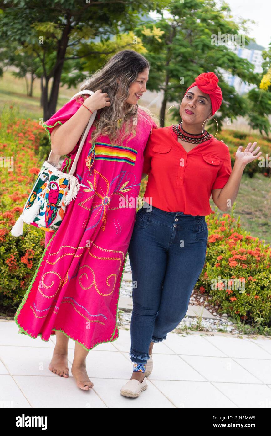 Latina friends walking down the street in the city. Friends laughing ...