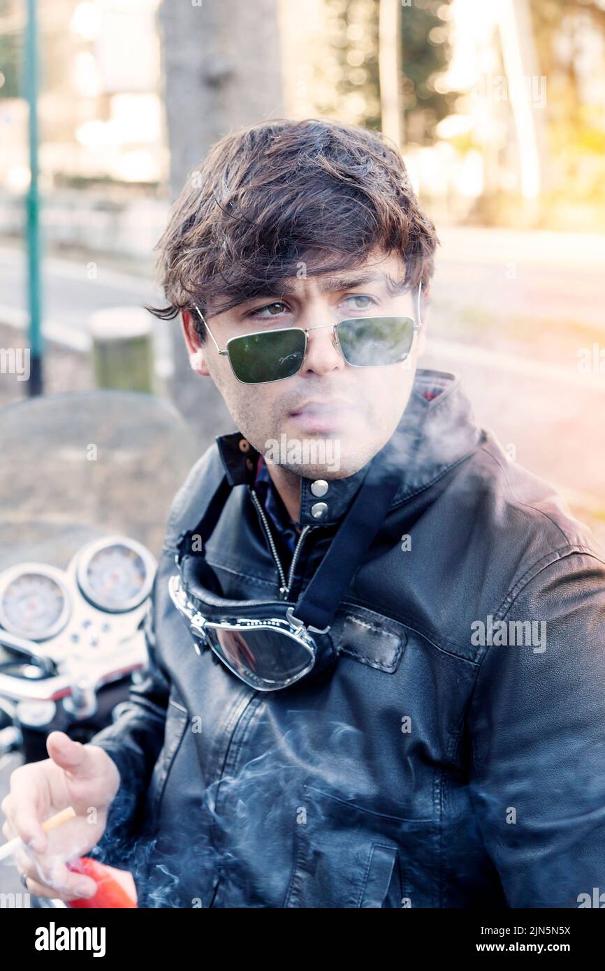 young biker relaxing smoking a cigarette Stock Photo - Alamy