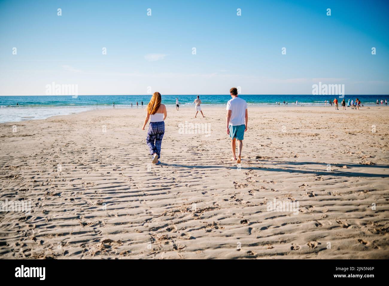 A couple walking in the sandy beach in Cornwall, England, UK Stock ...