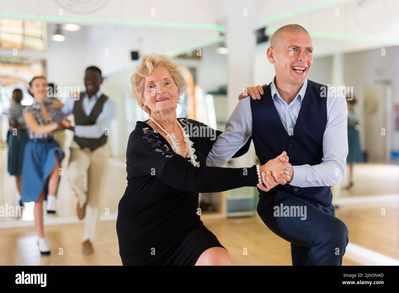 Mature woman dancing swing with young man Stock Photo - Alamy