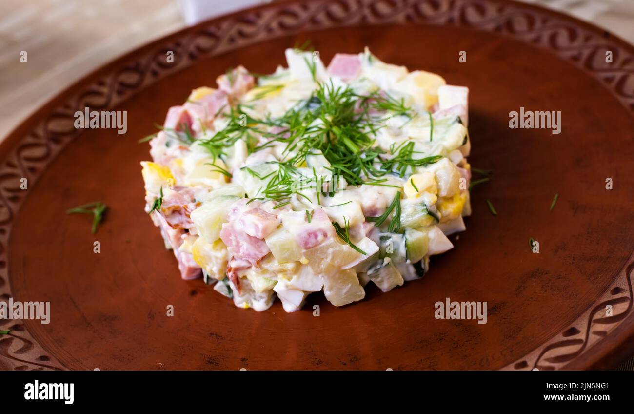 traditional Russian salad with peas and mayonnaise, served in a ...