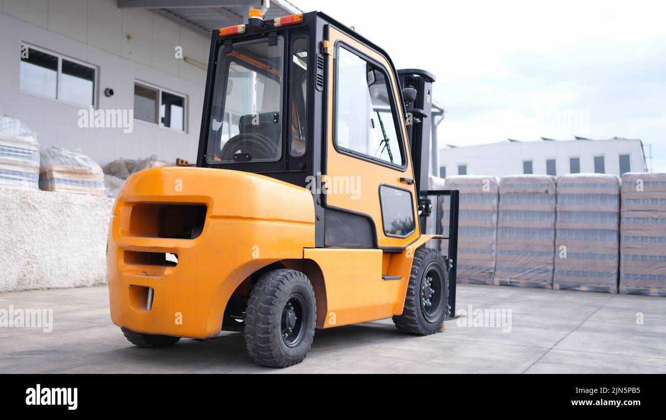 Reliable yellow forklift in warehouse. Loader in large outdoor ...