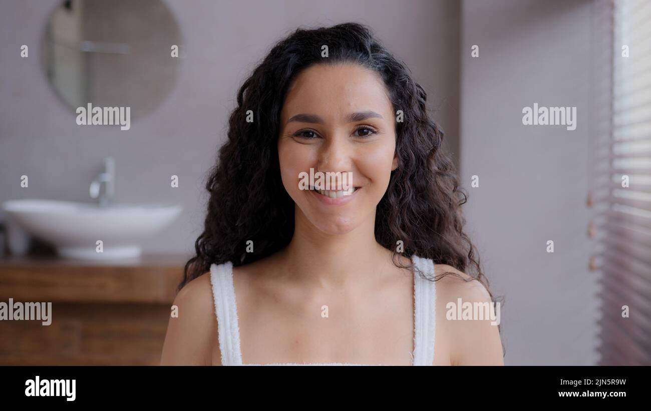 Close-up young attractive happy woman standing in bathroom looking at ...
