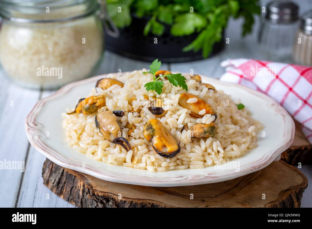 Mussel rice pilaf. Rice with mussels on small white plate on ceramic ...