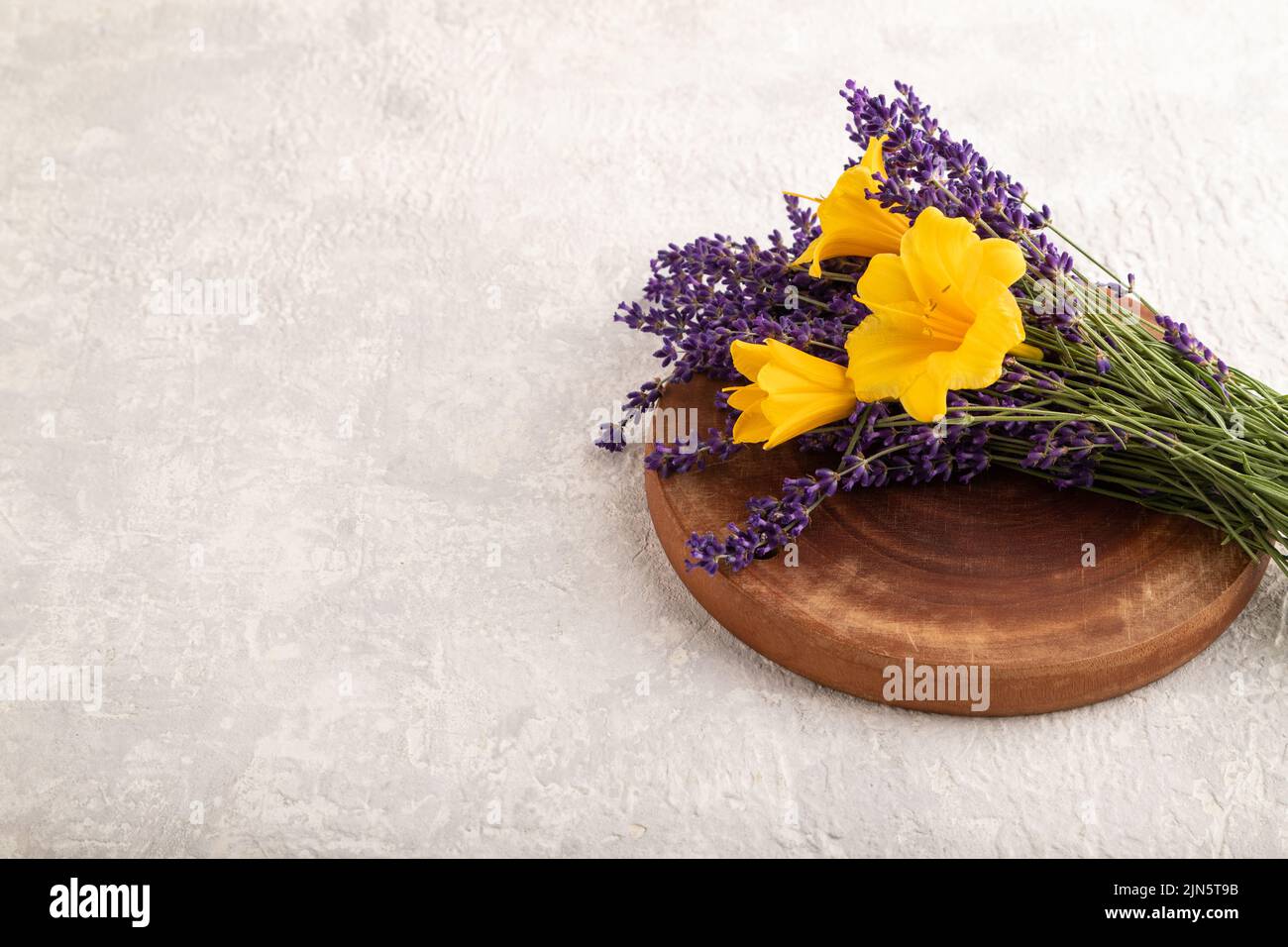 Beautiful day lily and lavender flowers on gray concrete background ...