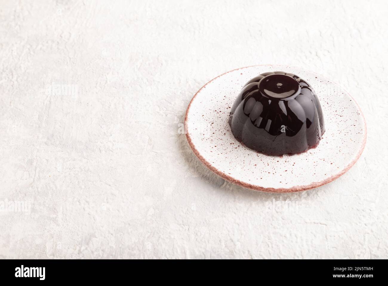 Black currant and grapes jelly on gray concrete background. side view ...