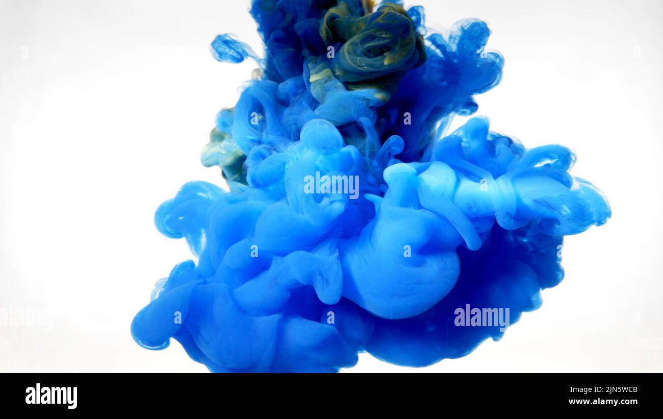 A blue ink spreading in water on white background Stock Photo - Alamy