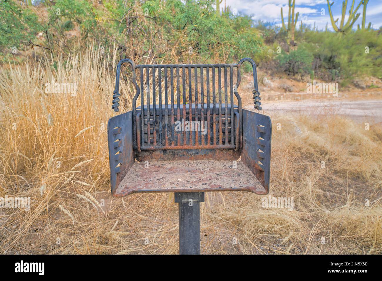 Post-mounted rusty campground grill against a shrubland in Tucson ...