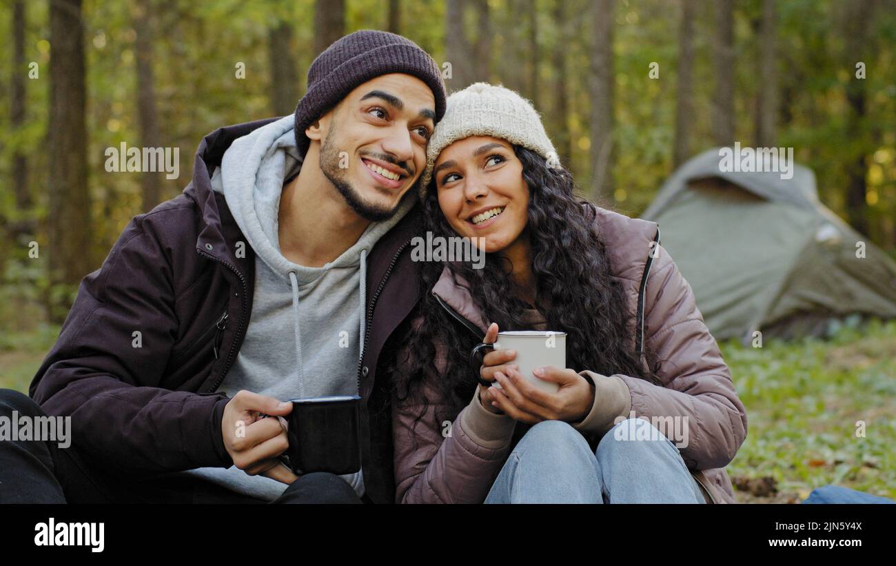 Happy married couple drinking hot drink outdoors in autumn forest young ...