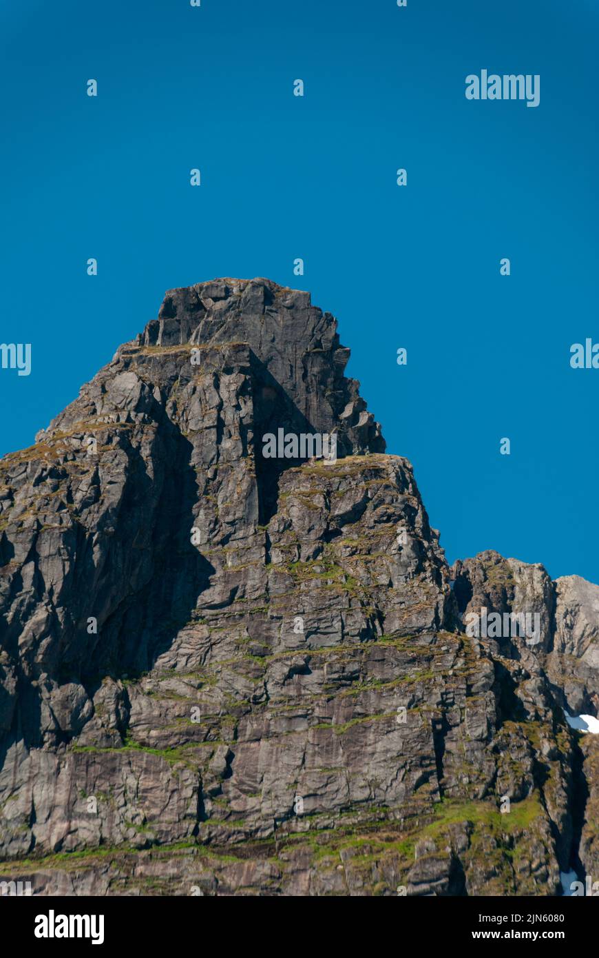 A vertical shot of the peaks of mountains against the sky in ...