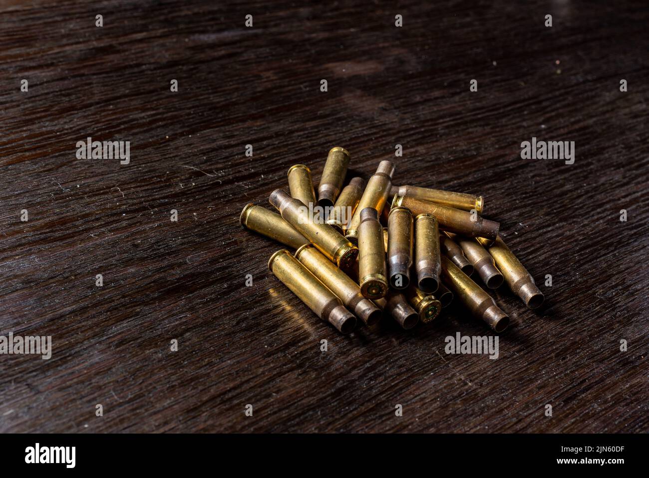 A close-up shot of empty bullet casings on a dark, wooden table Stock ...