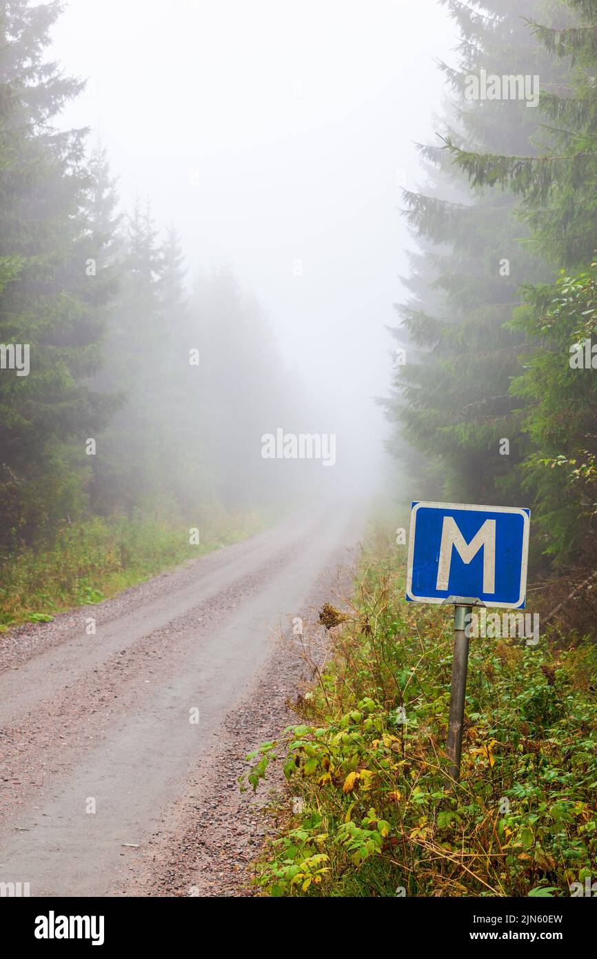 Meeting place road sign by a foggy forest road Stock Photo - Alamy