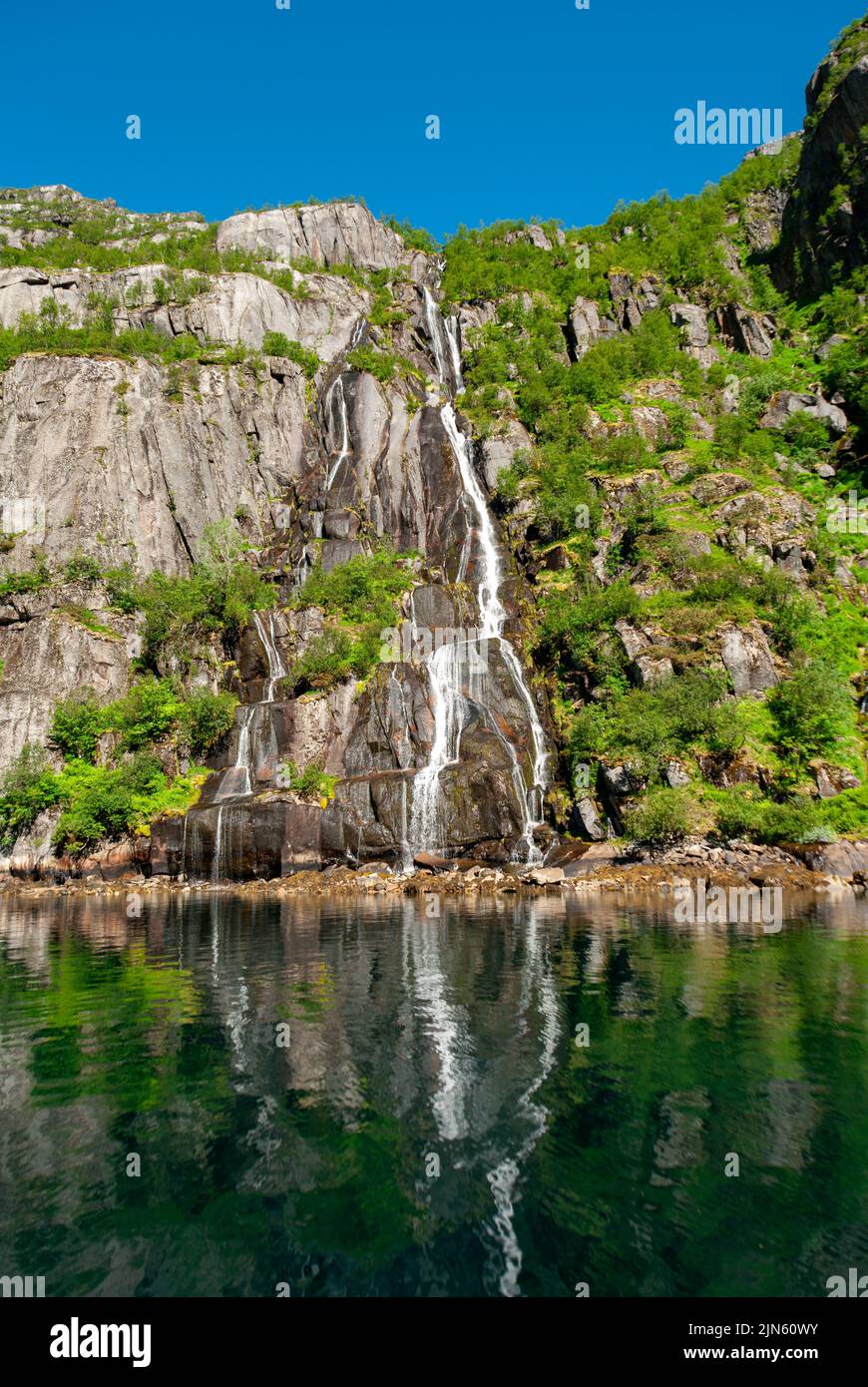 A vertical shot of beautiful waterfall on Trollfjorden Lofoten Islands ...