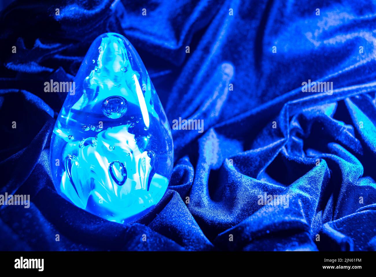 Closeup shot of a Blue-Violet Egg shaped glass ball on the Blue-Violet ...