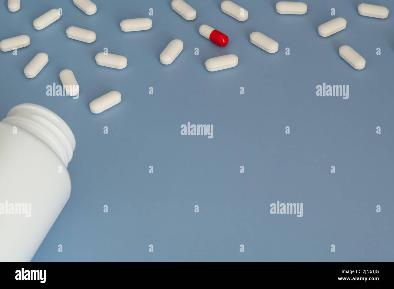 Vitamins tablets supplements coming out of bottle with one Red and ...