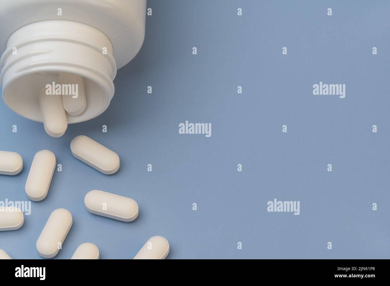 Vitamins tablets supplements Medicine coming out of bottle on Blue ...