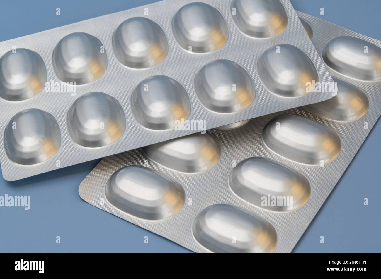 Two Packs of Vitamins tablets supplements medication on Blue background ...