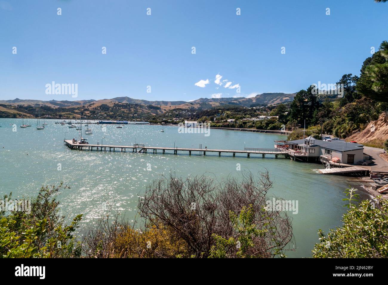 A long jetty in Akaroa bay is a former French settlement in the small ...