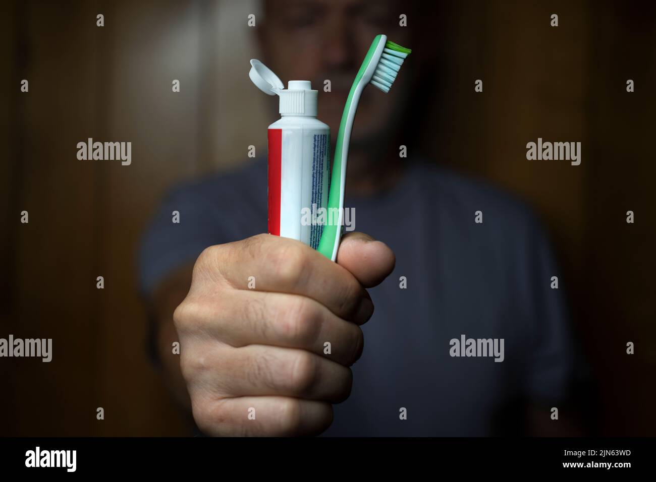 a man with a toothbrush and a tube of toothpaste in his hand Stock ...