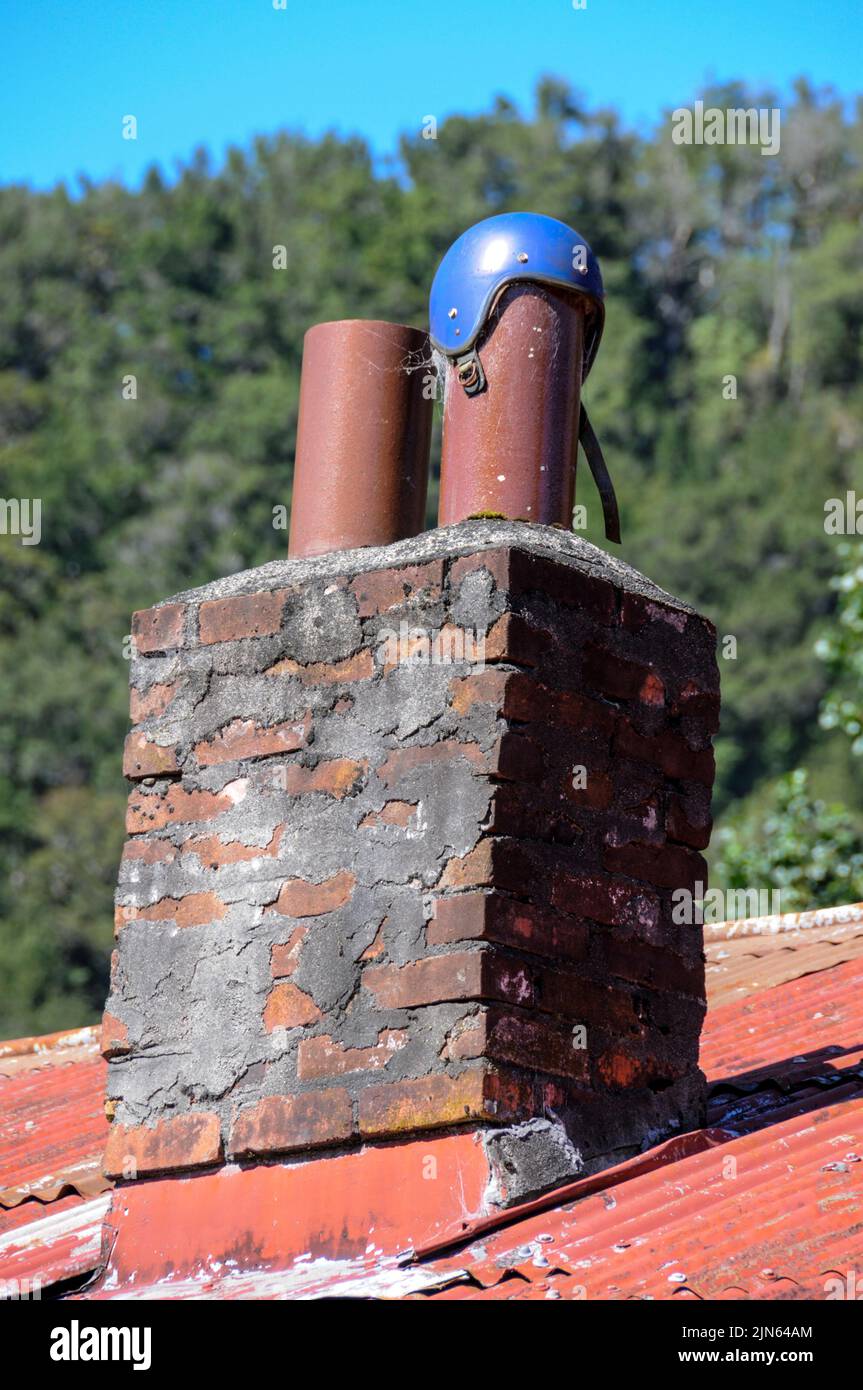 An eccentric resident crash helmet on top of one of the chimneys at his/her home on the south ...