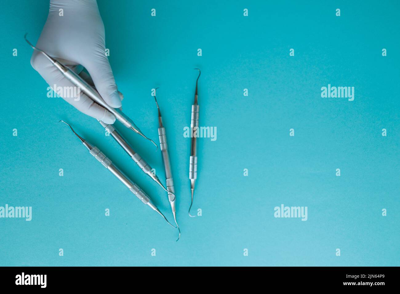 Close up view hand of a dentist in a latex glove taking a periodontal ...