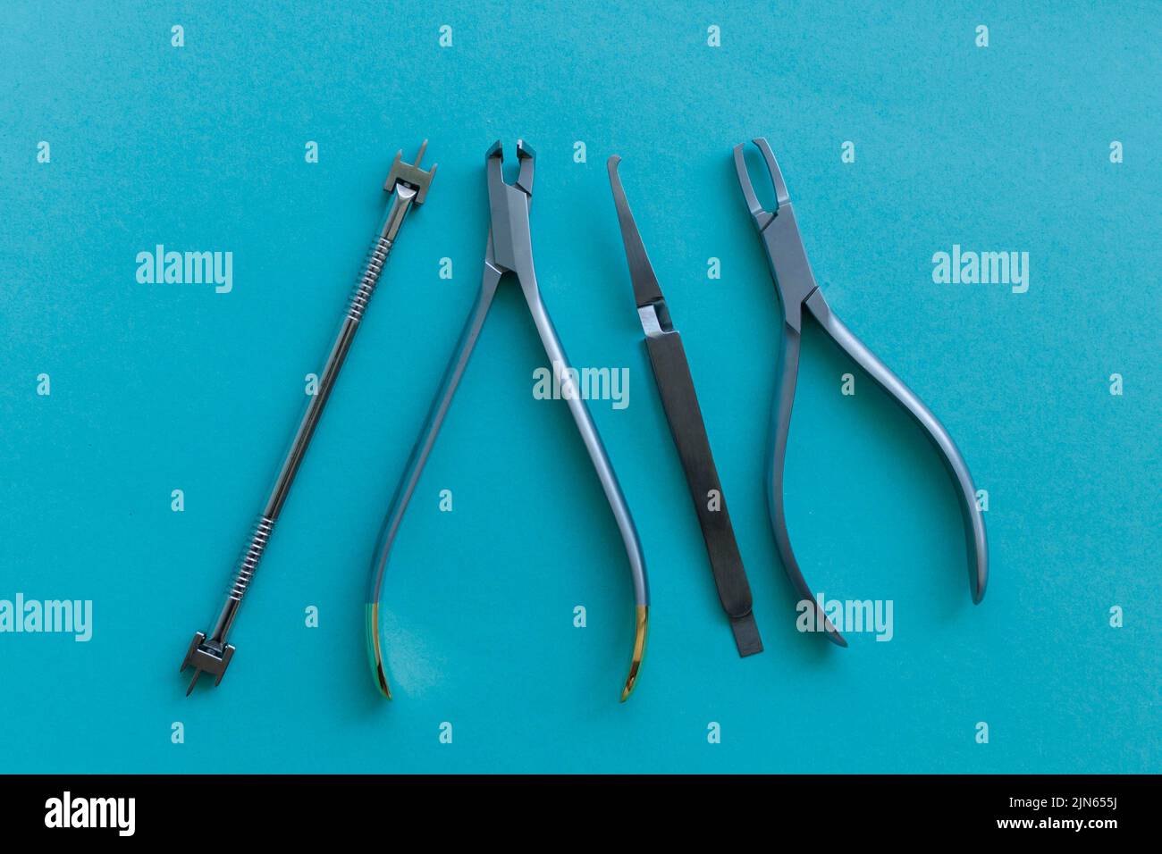 Dental tools for removing teeth on a blue background Stock Photo - Alamy