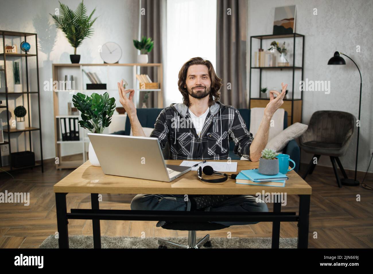 Relaxed caucasian man in casual wear sitting on workplace with modern ...