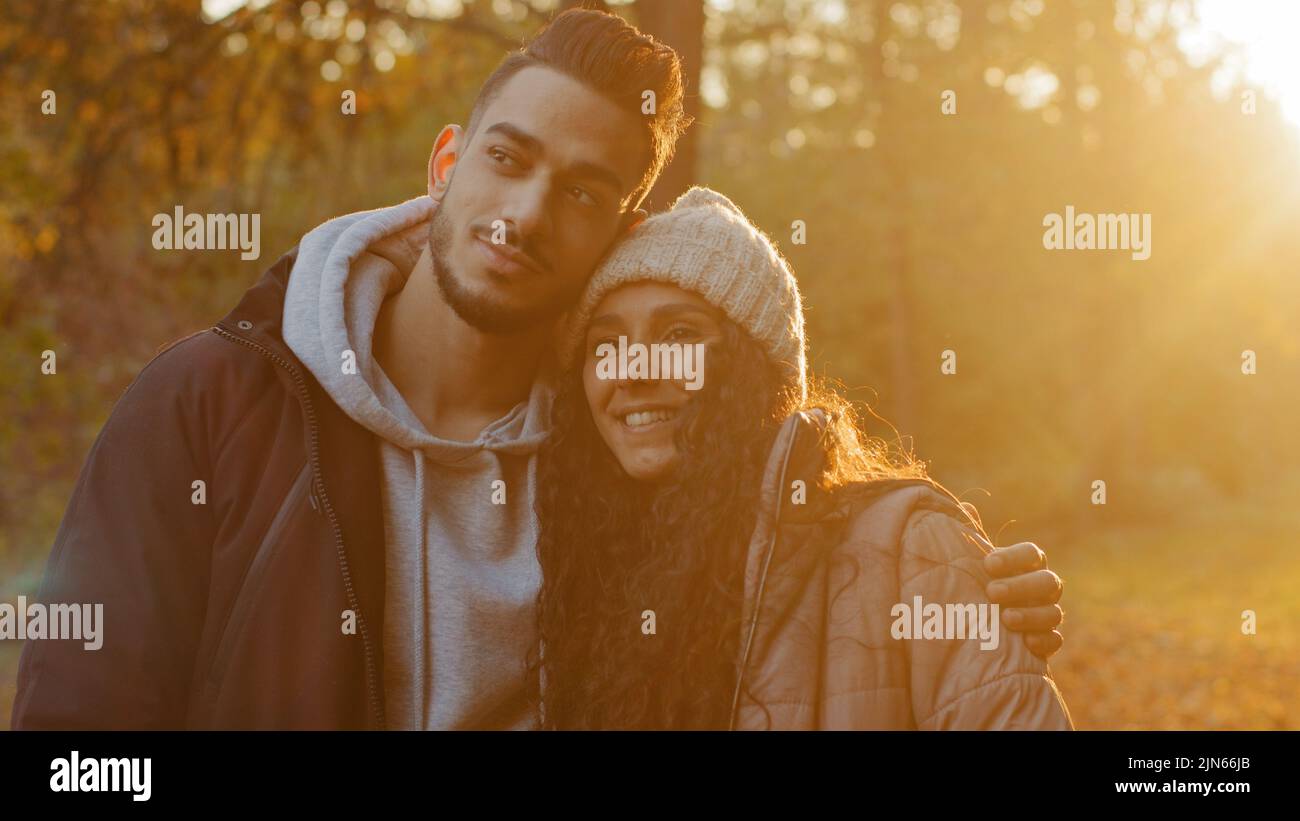 Young happy couple in love standing outdoors hugging admiring sunset in ...
