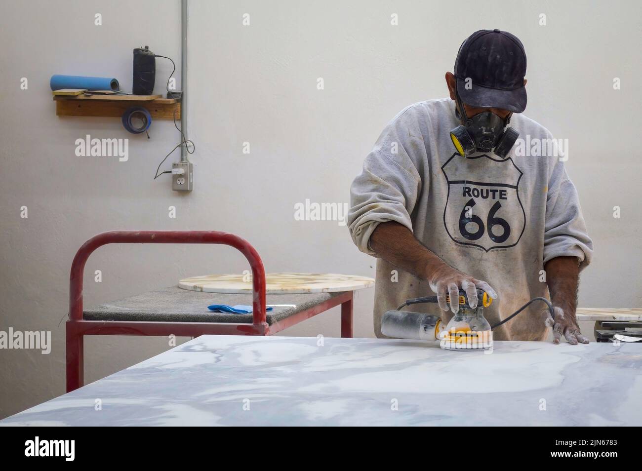 A professional woodworker using a woodworking sander on a piece of ...