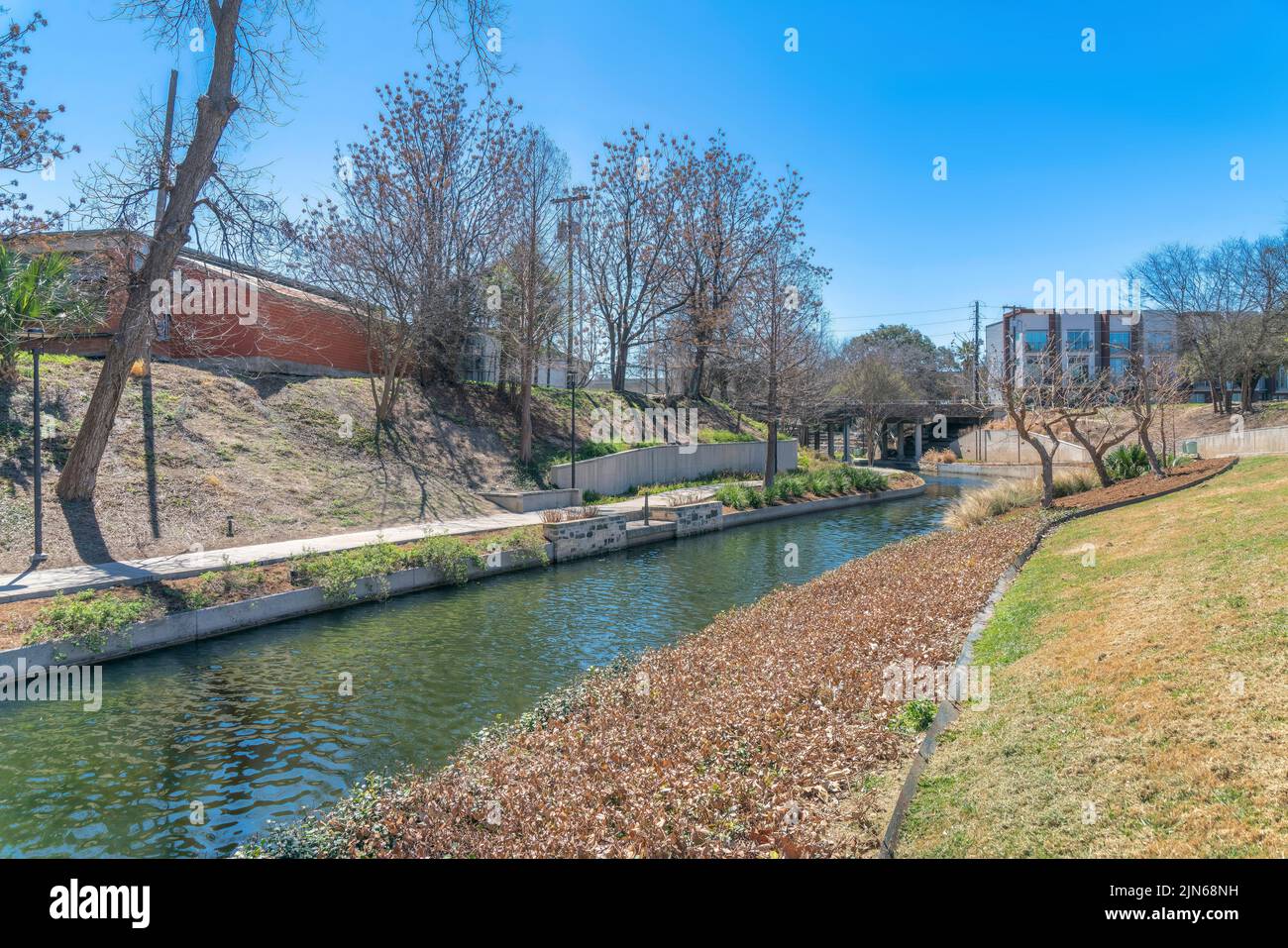 Small river at San Antonio, Texas with concrete walkway on the side ...