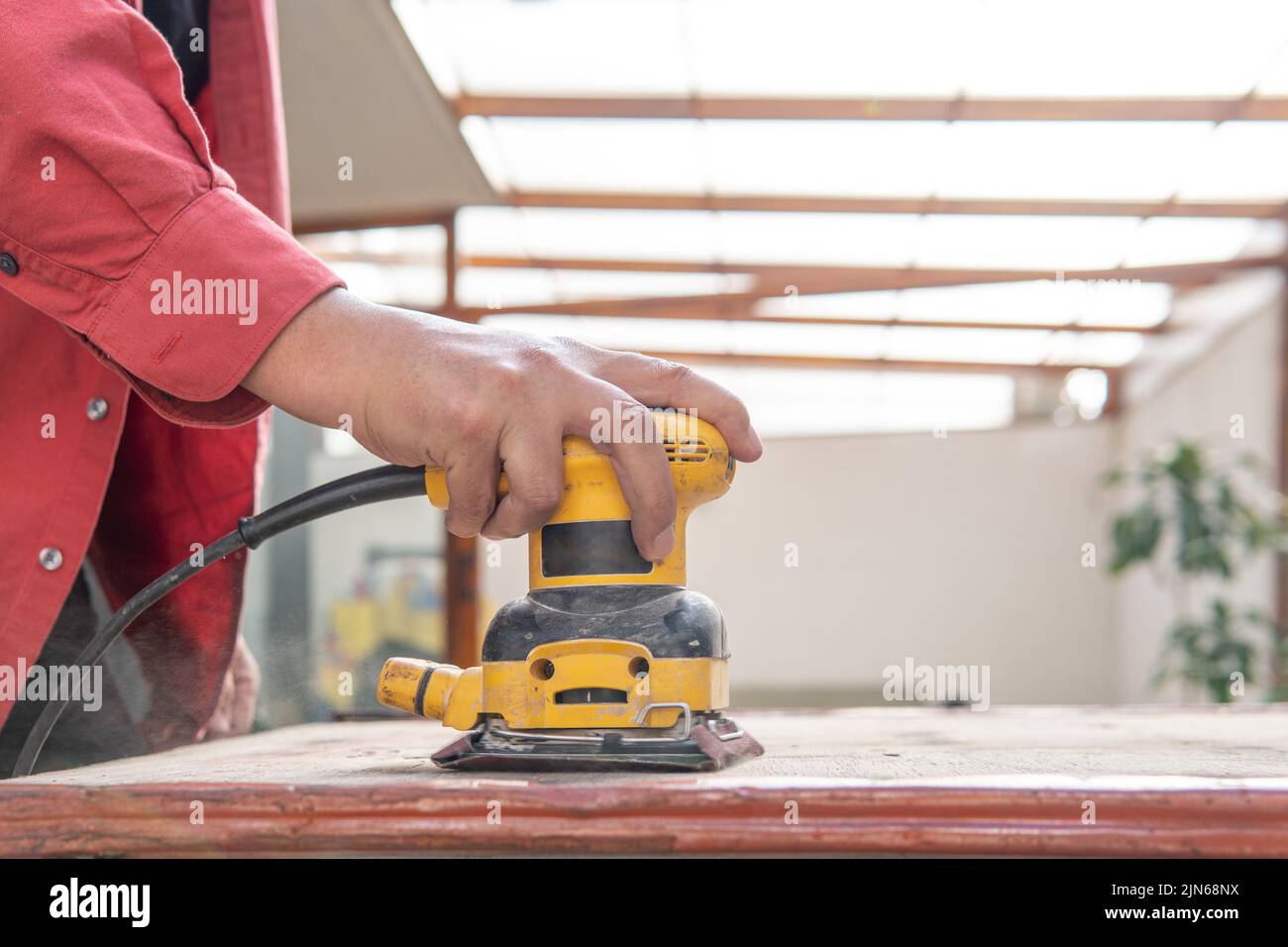 Hand of an unrecognizable man using a sander on a piece of wood ...