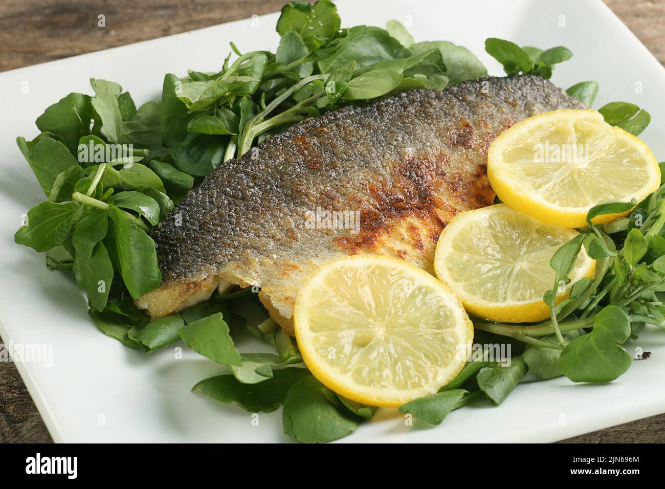 fried sea bass with watercress Stock Photo - Alamy