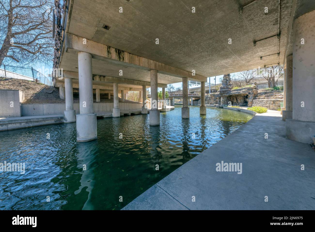 Concrete walkway near the river under a bridge at San Antonio, Texas ...