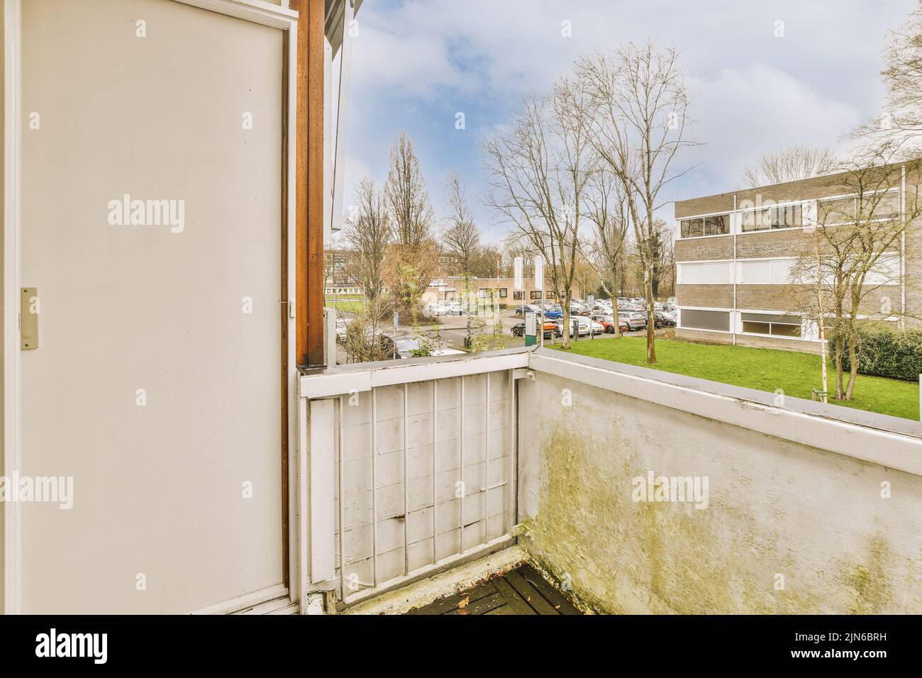 The front view of buildings with pavement and vegetation describing ...