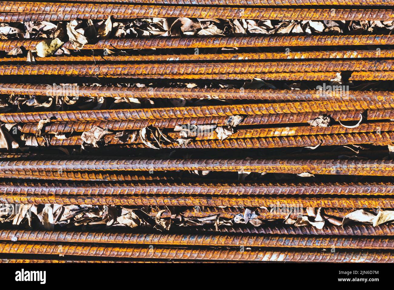 Top view old rusted iron bars and dry leaves on floor. Close up to ...