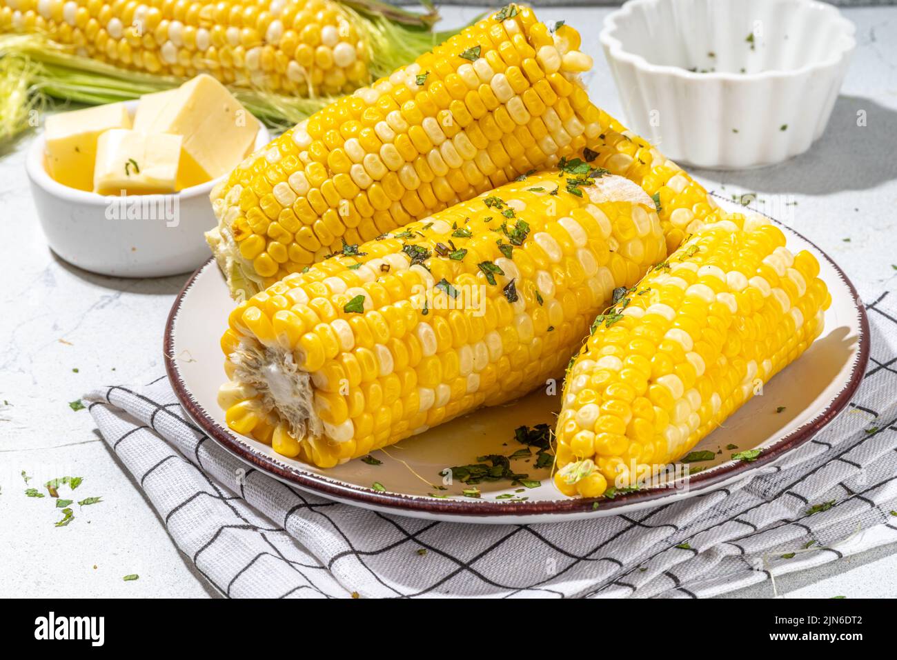 Boiled corn with butter and herbs. Ripe yellow organic cooked corn cobs ...