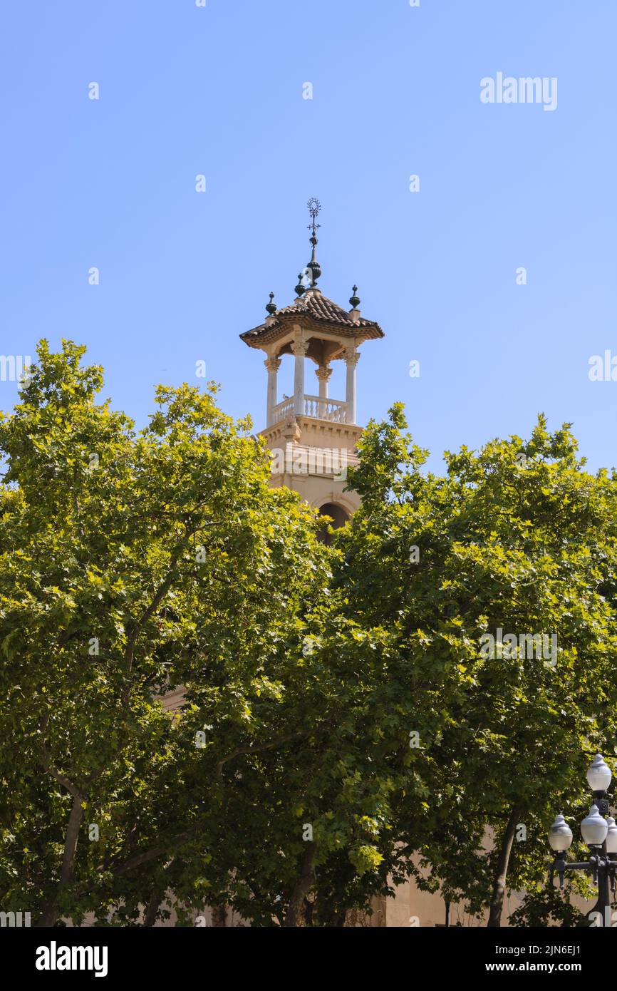 Vertical shot of a small ancient tower behind some trees outside of the ...